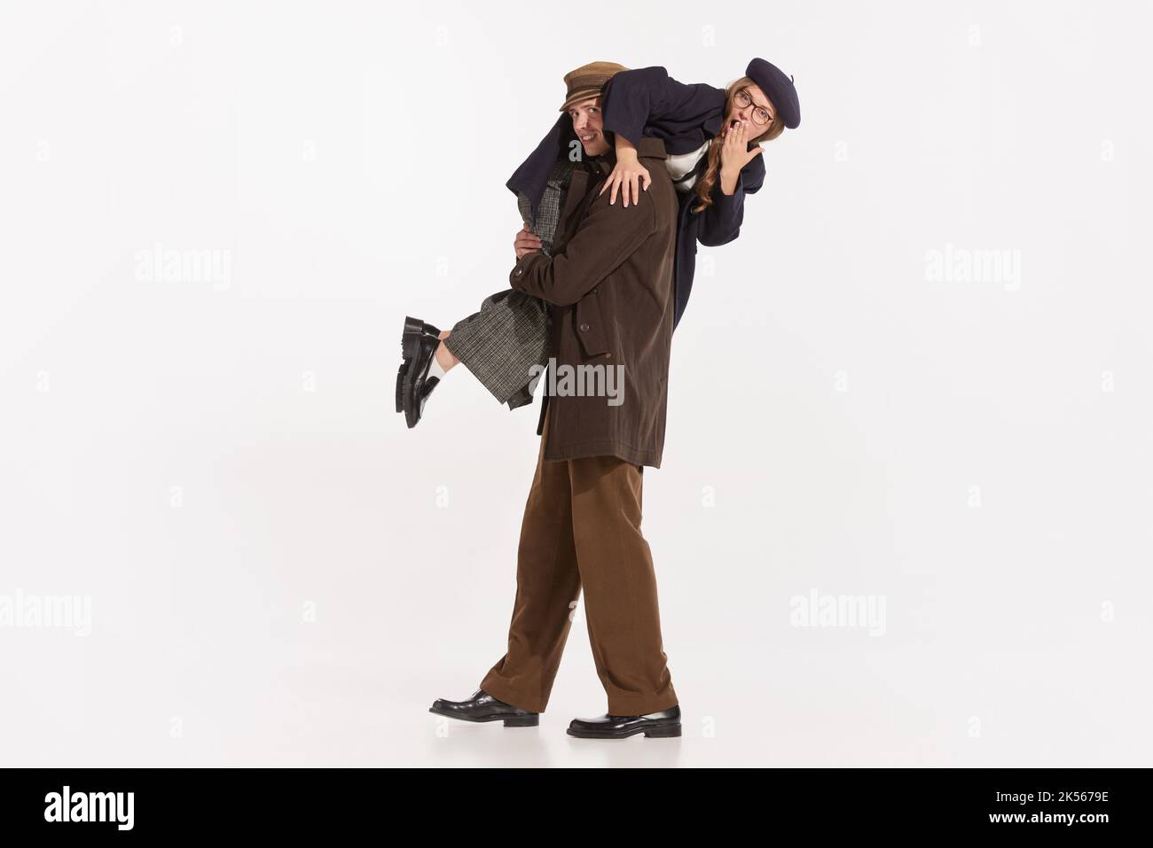 Portrait of stylish people in autumn clothes, man carrying woman on his ...