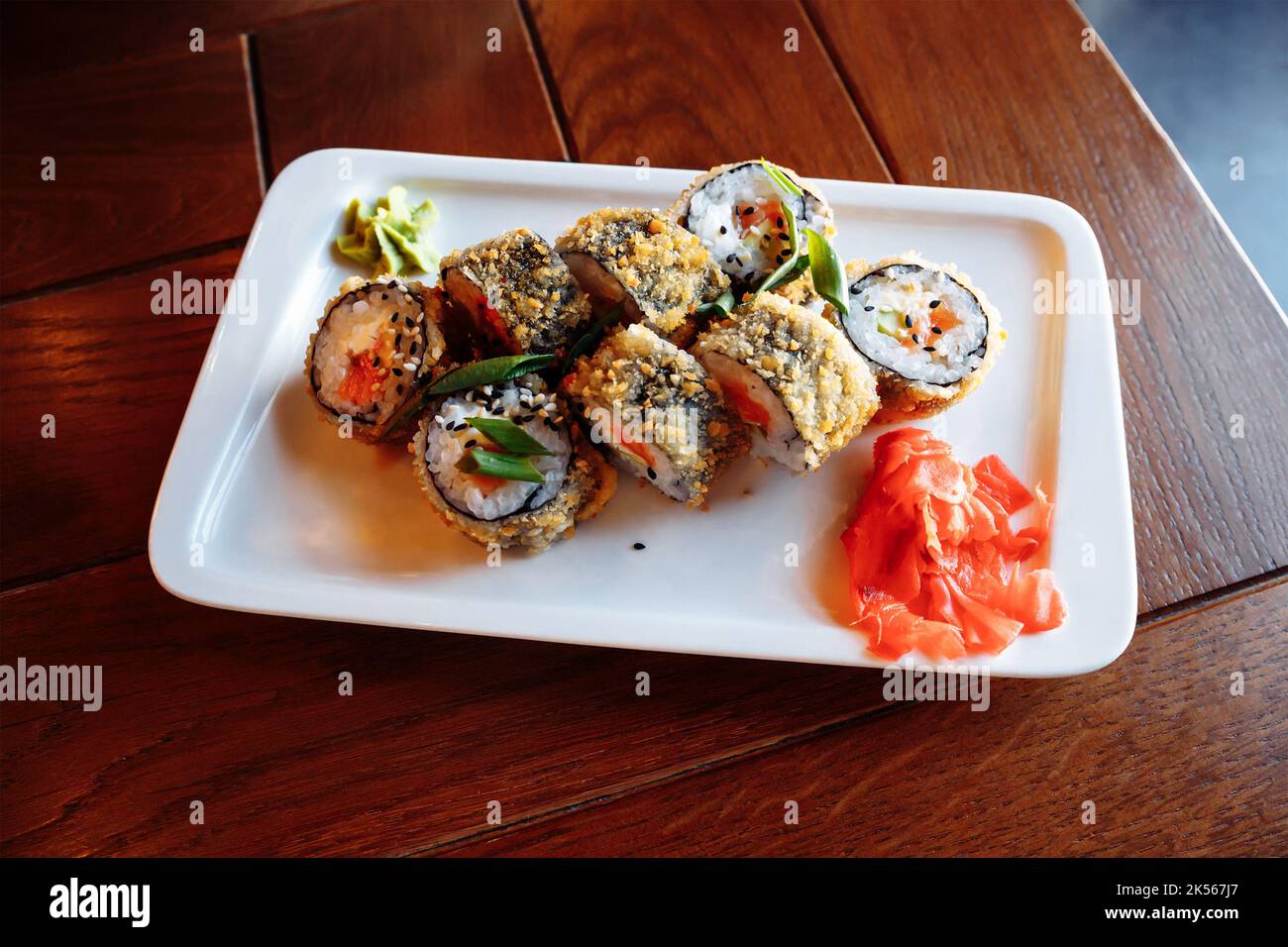 Baked Maki sushi with tempura, baked rolls on white rectangular plate ...
