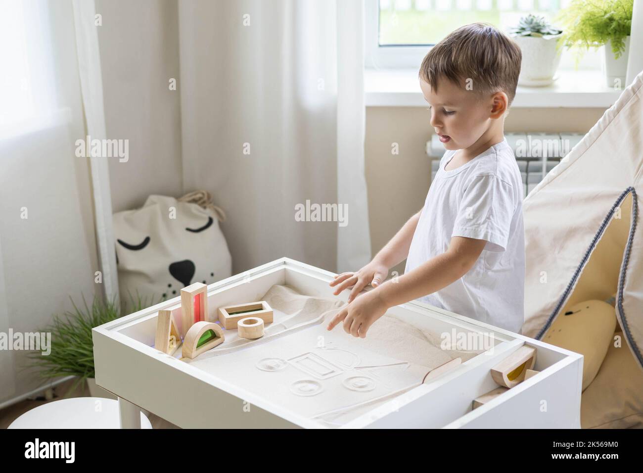 Cute male kid playing with sensory box kinetic sand table Montessori ...