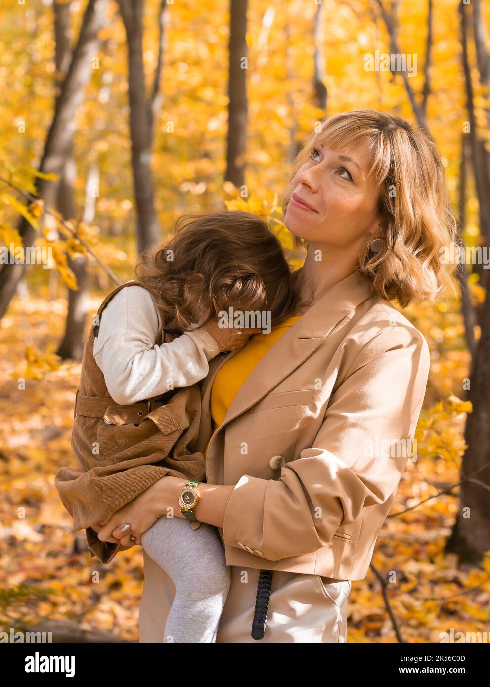 Mother comforting her crying little girl in autumn nature. Emotions and ...