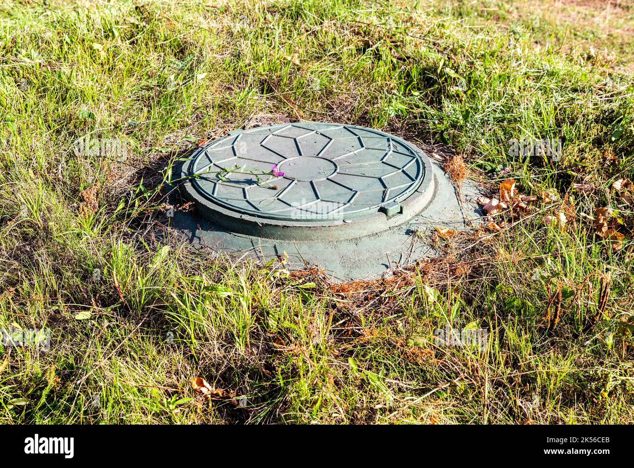 Covered sewer manhole of rural septic tank with green plastic cover ...