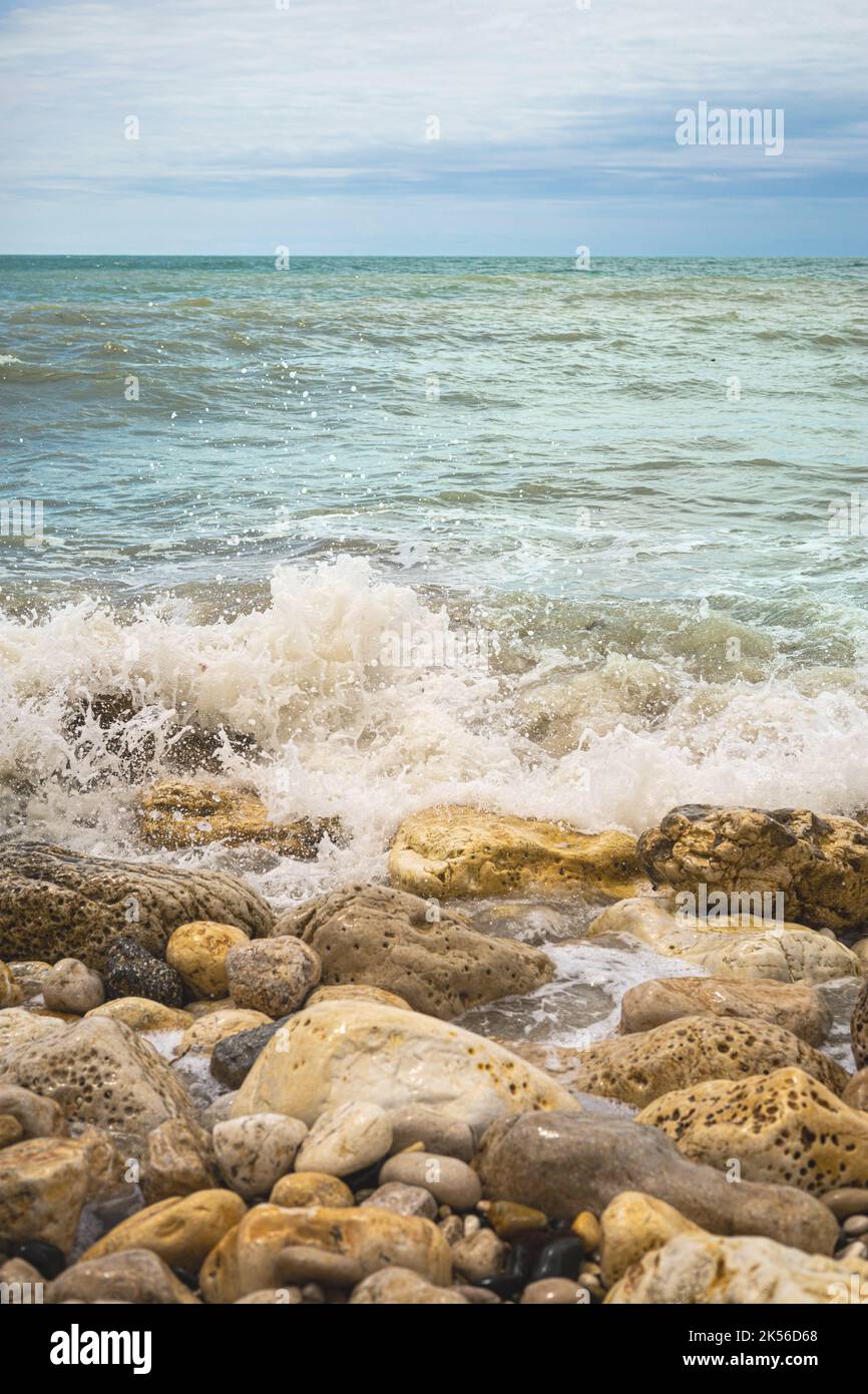 Empty dock pier sunny beach sea wave splash water cobblestones rock ...