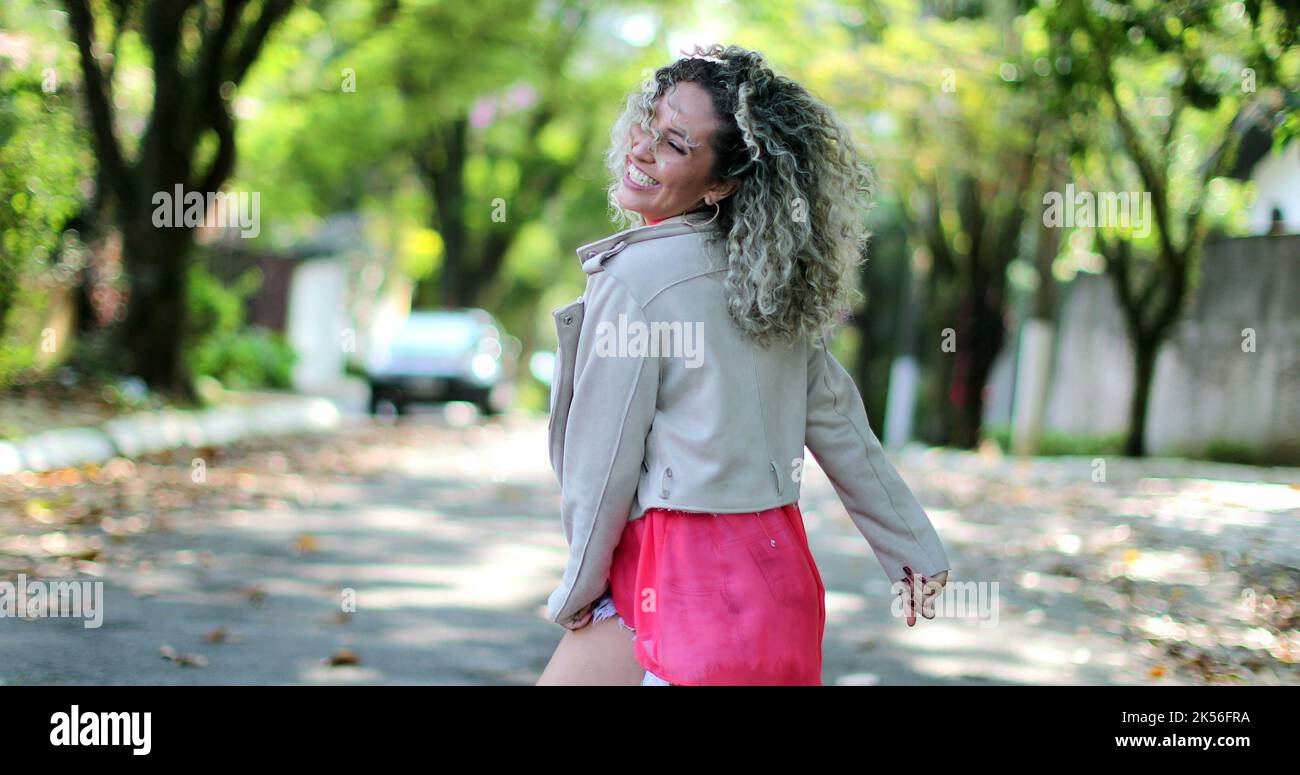 Ecstatic woman jumping with joy celebrating success outside in street ...