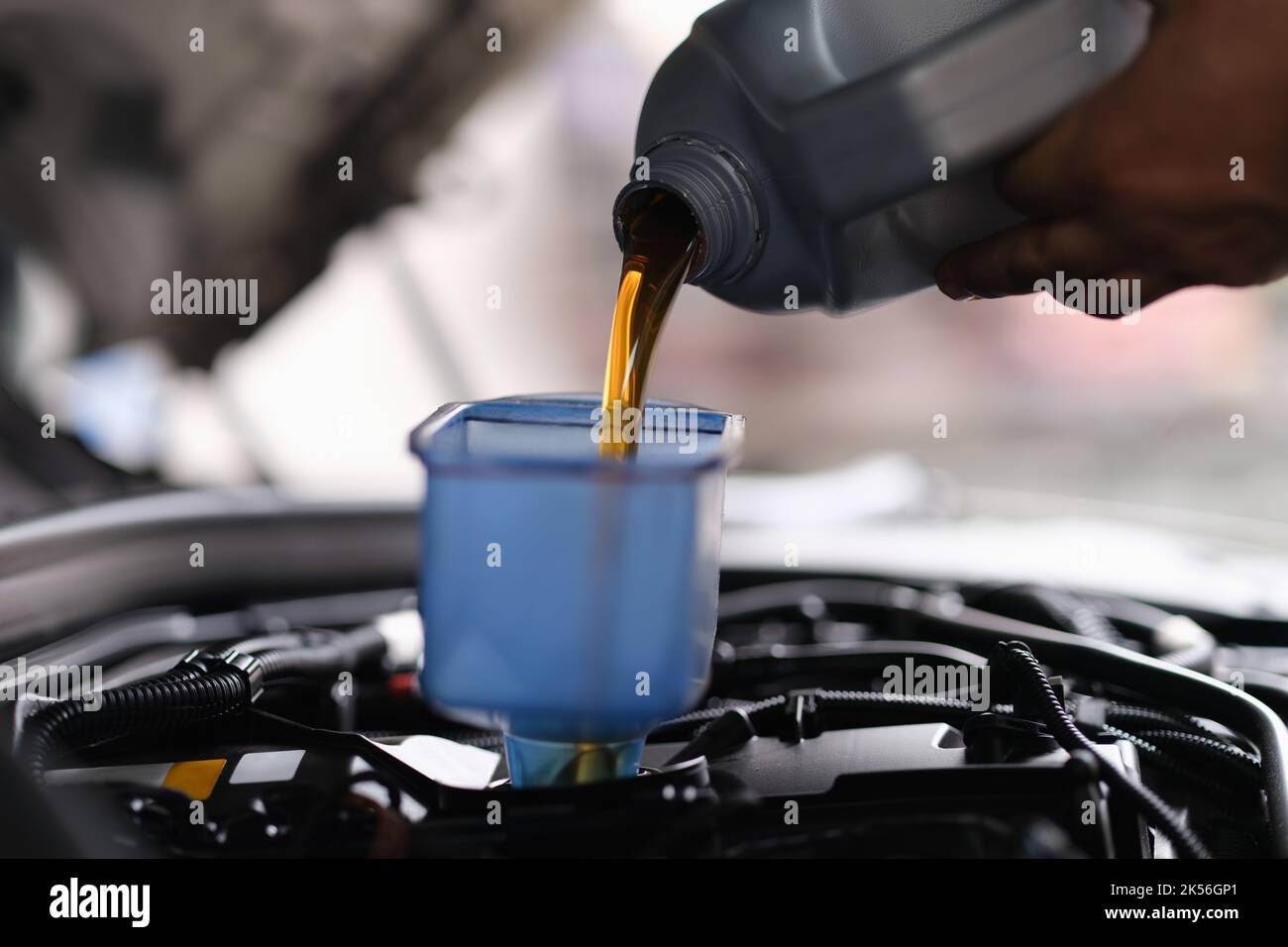 Mechanic pouring engine oil into engine in car service Stock Photo - Alamy