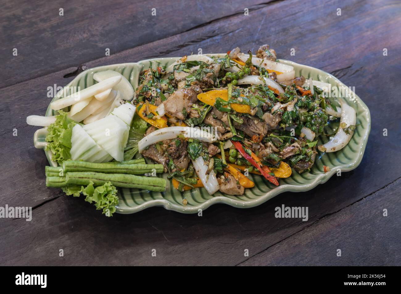 Spicy stir-fried wild boar with herbs and black peppers on green ...