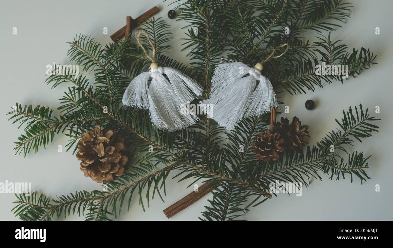 two macramé white angels Christmas decoration on holiday tree branches ...