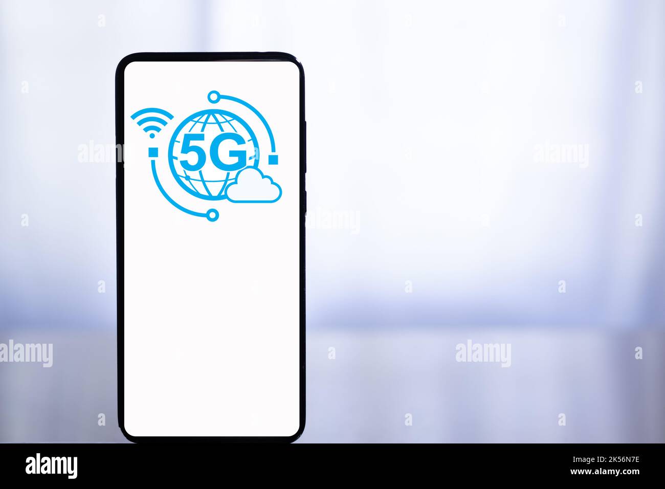 Close up of a smart phone showing 5G network on a white background ...