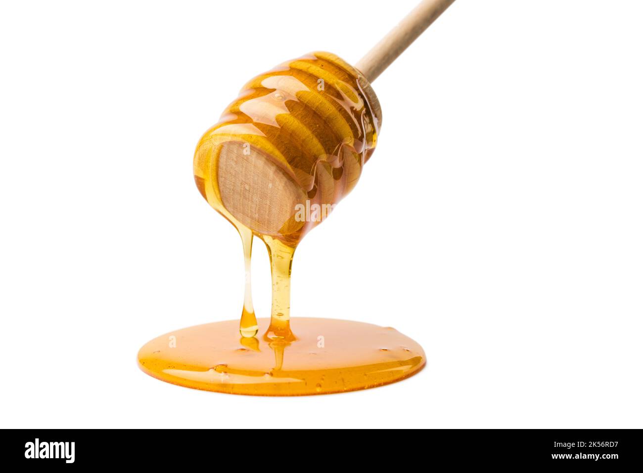 Honey dripping from wooden dipper on puddle, isolated on white Stock ...