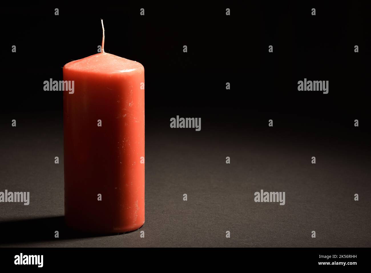Red candle isolated on black background. not burning Stock Photo - Alamy