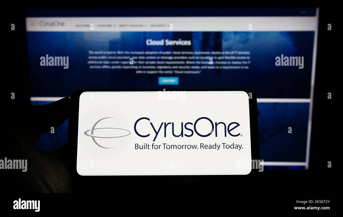 Person holding mobile phone with logo of American data center company ...