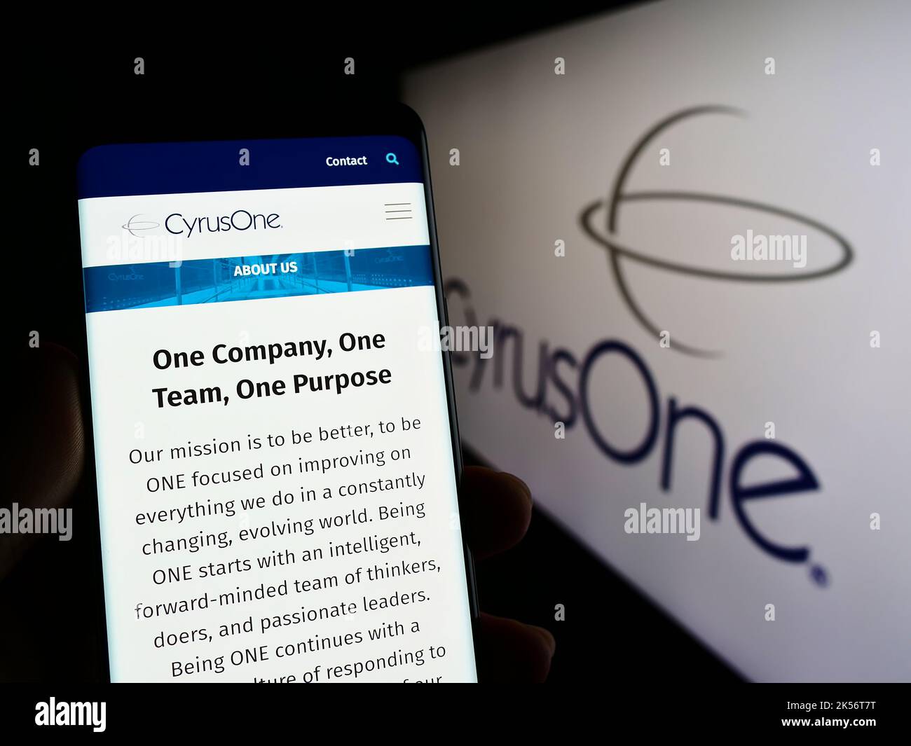 Person holding cellphone with webpage of US data center company ...