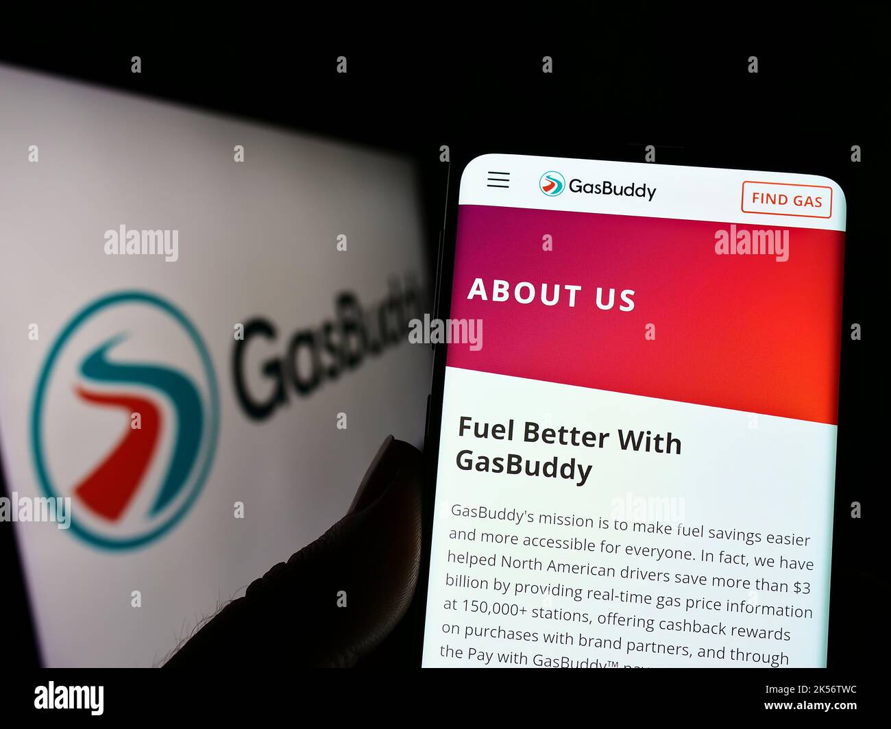 Person holding smartphone with webpage of US fuel pricing company ...