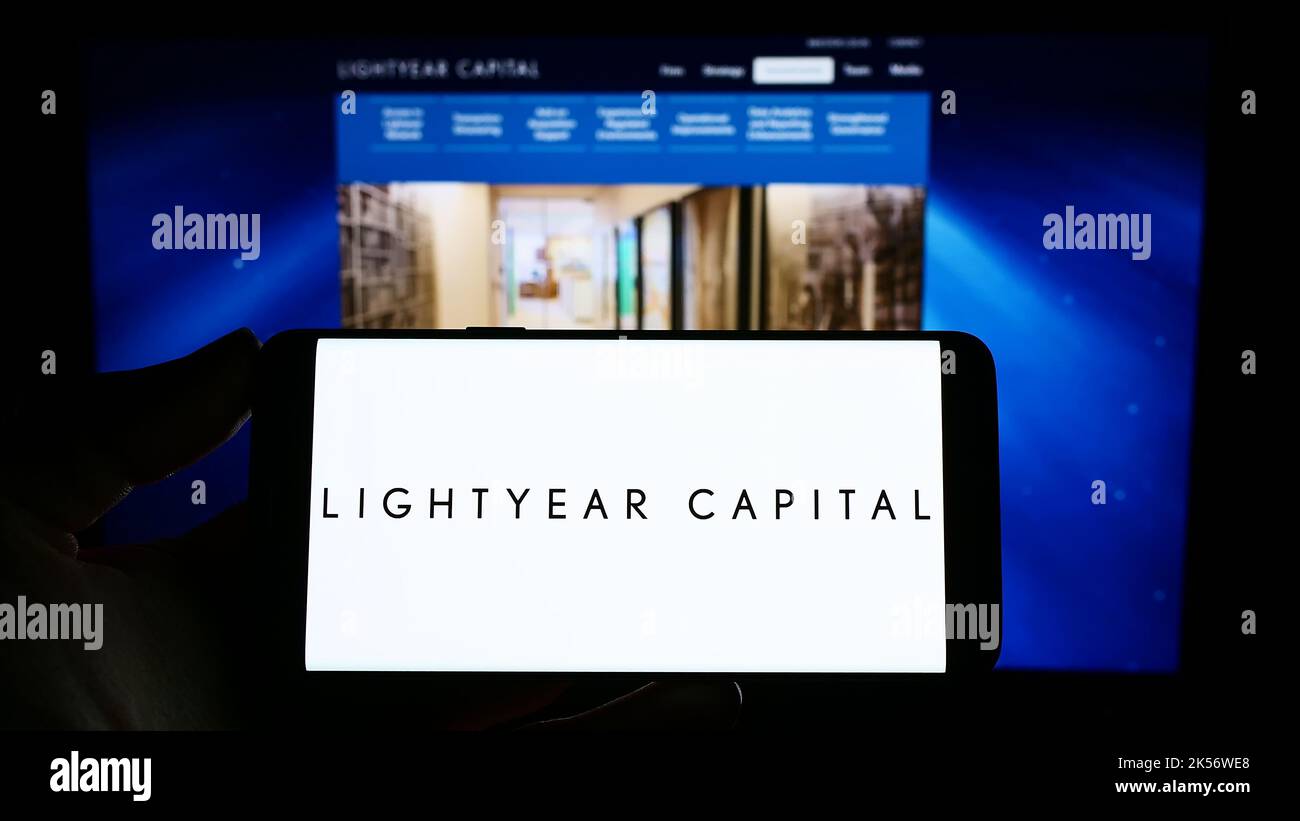 Person holding mobile phone with logo of US private equity company Lightyear Capital on screen ...