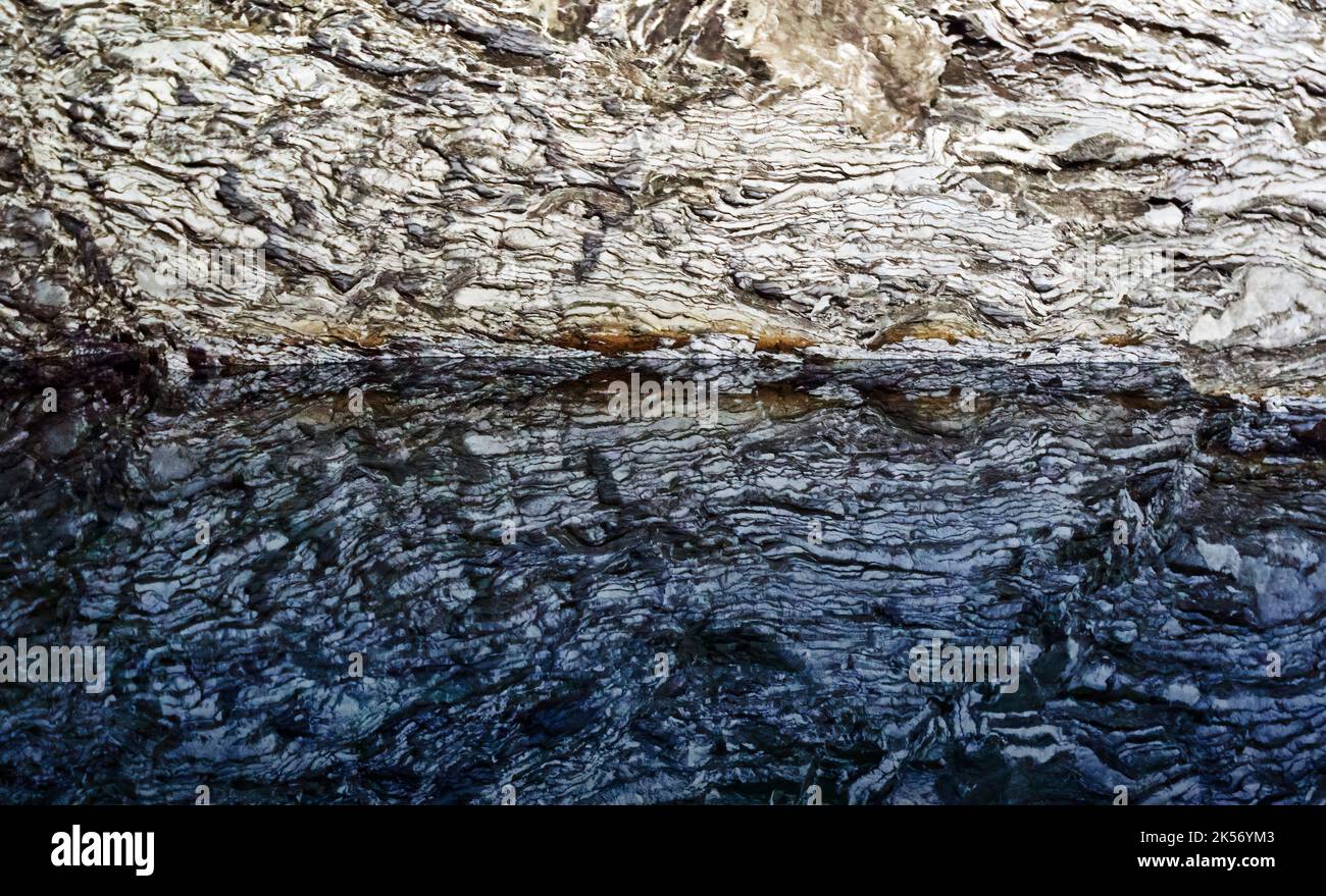 Reflection of anhydrite banded by clay deposits in the water of a ...