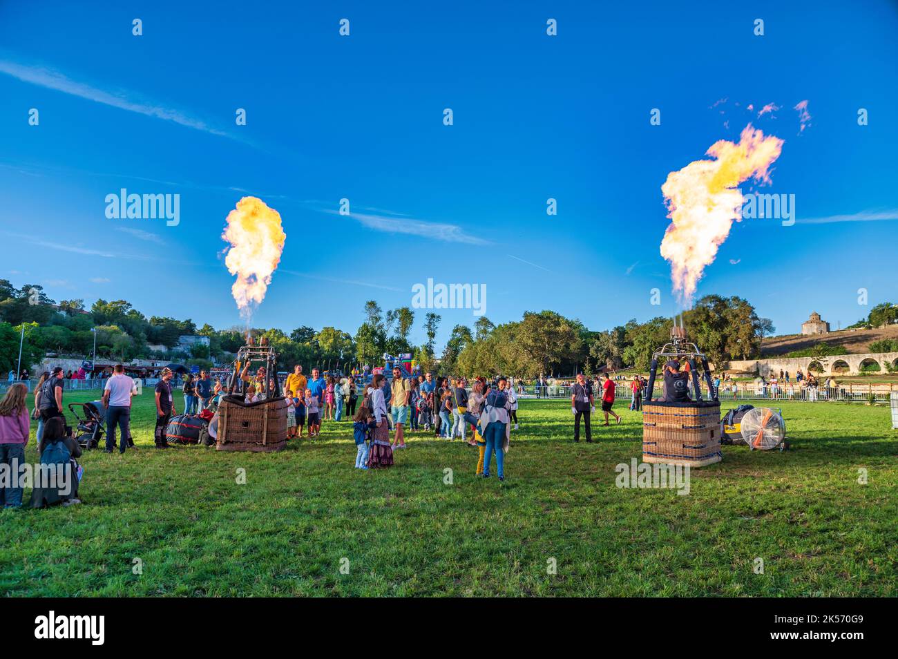 Crowd enjoying a hot air balloon event with dramatic flame displays in ...