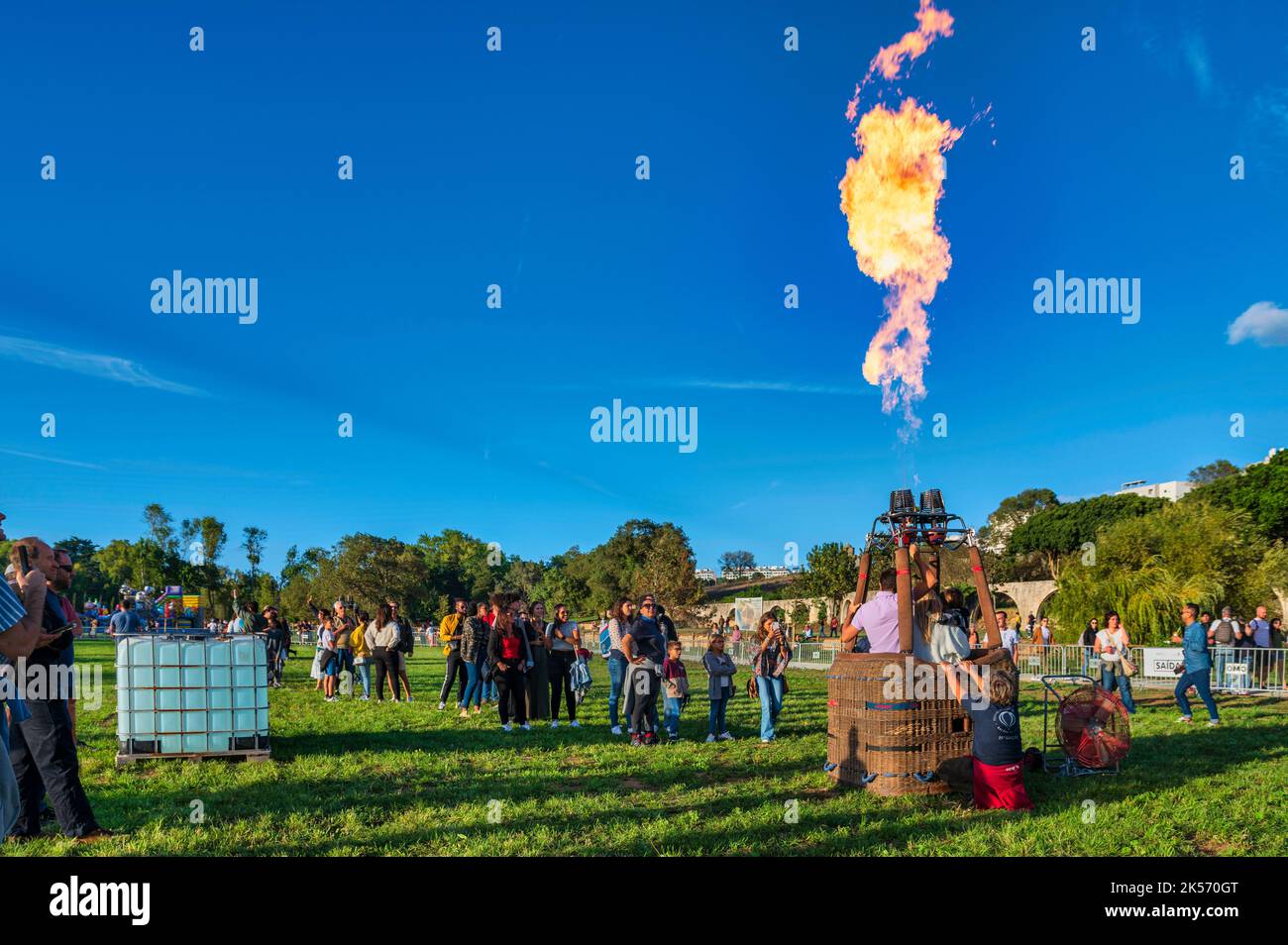 Crowd enjoying a hot air balloon event with dramatic flame displays in ...