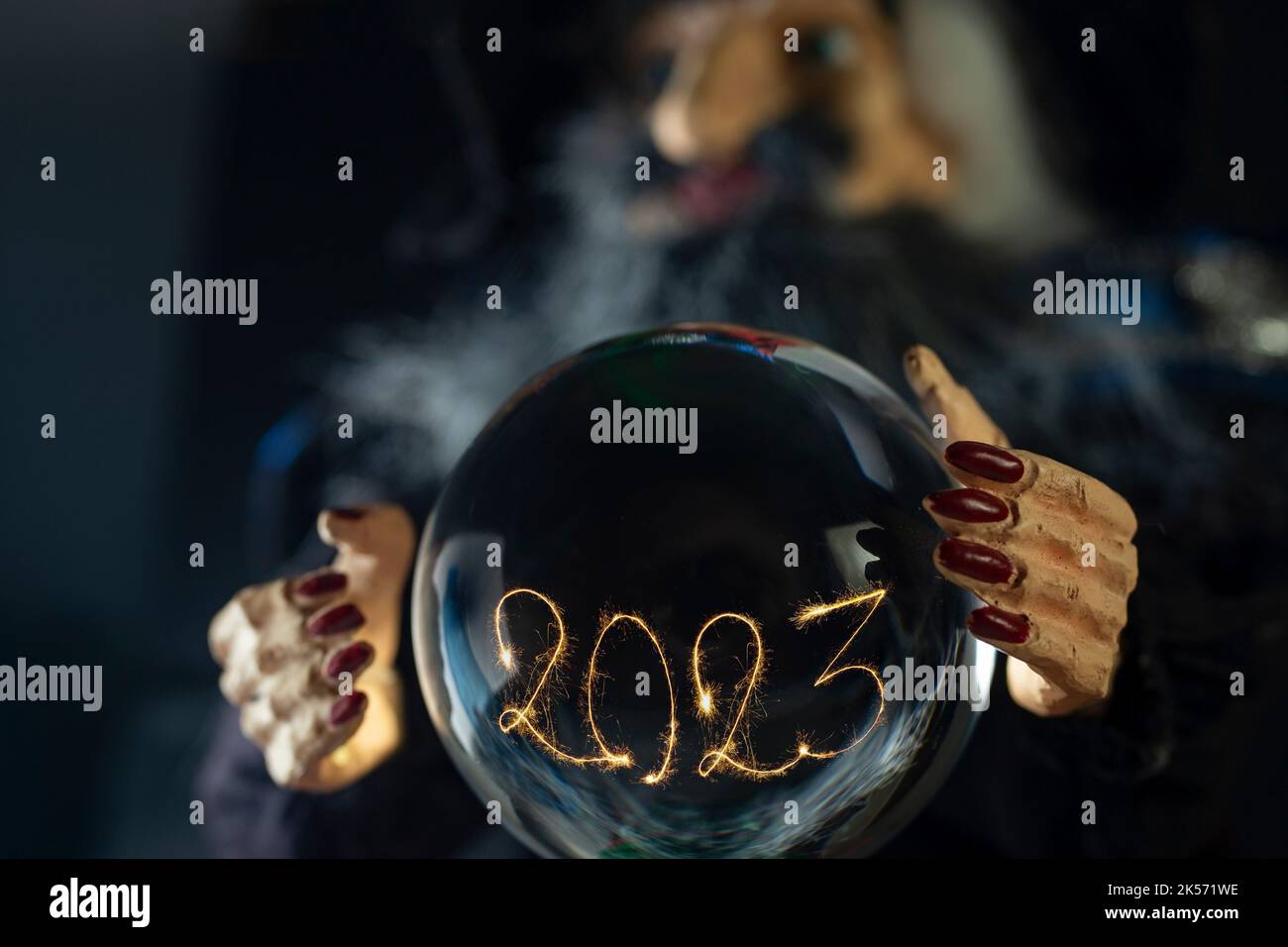 2023 written with sparklers and sparks, inside a crystal ball. wizard ...