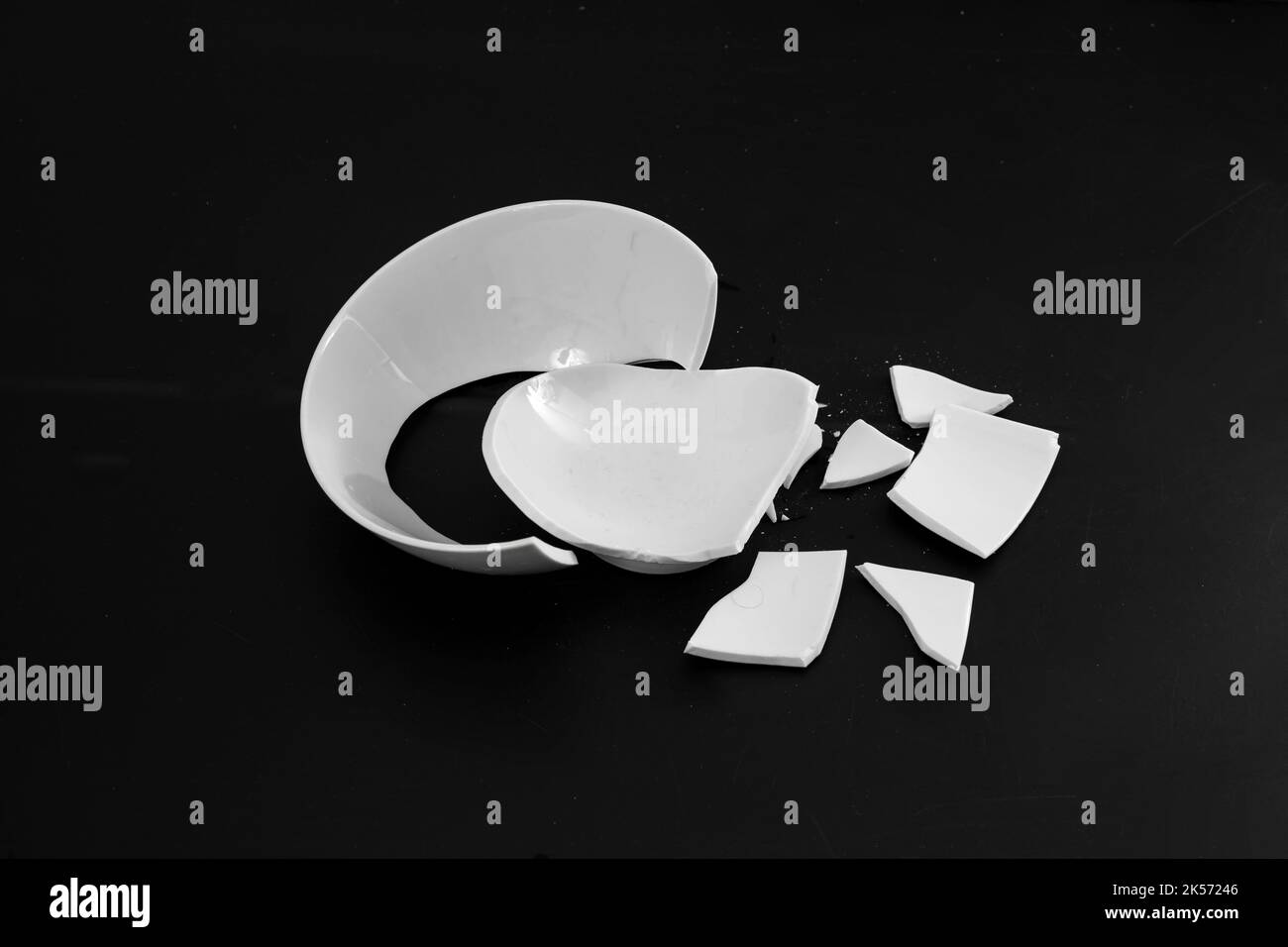 broken to pieces white bowl, isolated on black background, side view ...