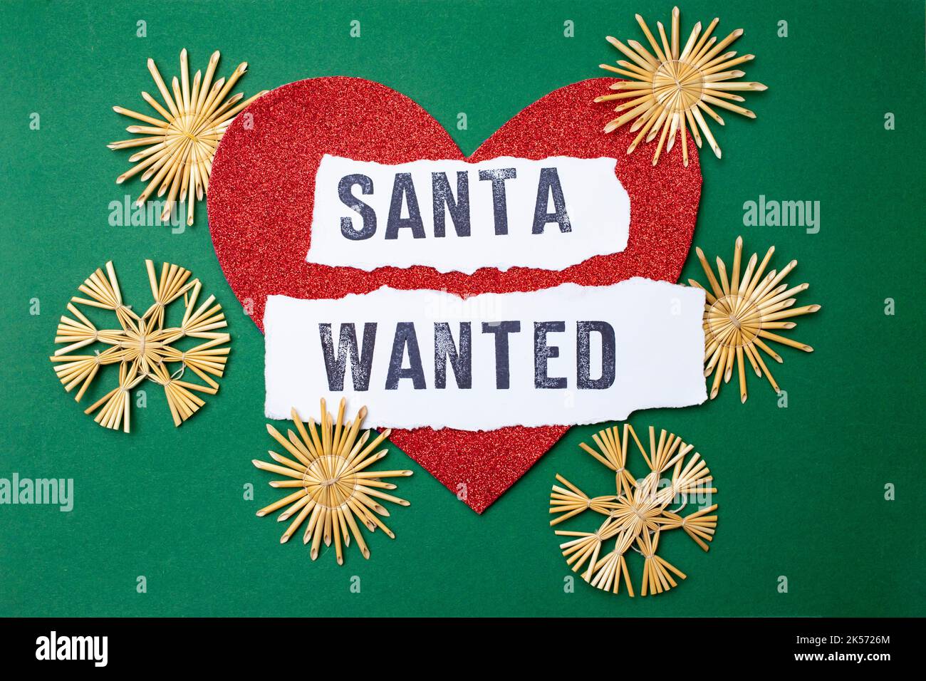 Santa wanted written on white paper strips, on a red glitter heart and ...