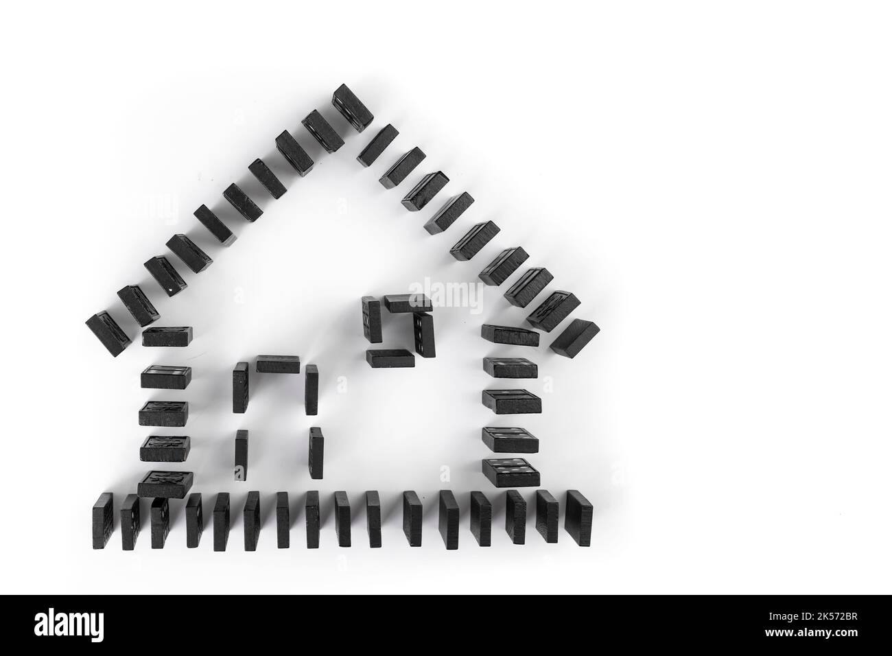 Black domino tiles arranged in the shape of a house isolated on white ...
