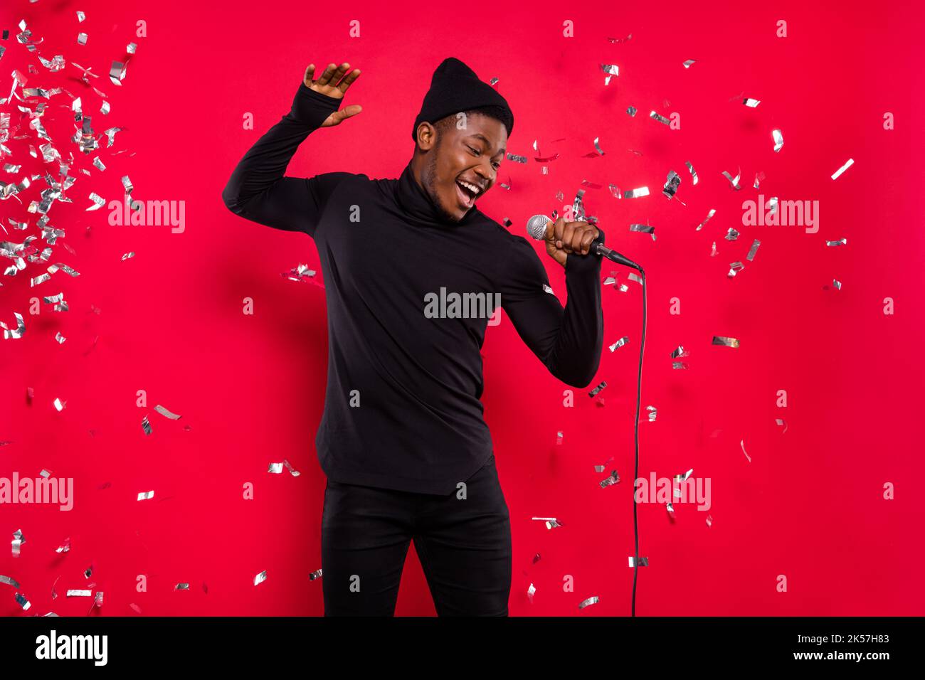 Portrait of attractive cheerful funny guy singing hit decor flying ...