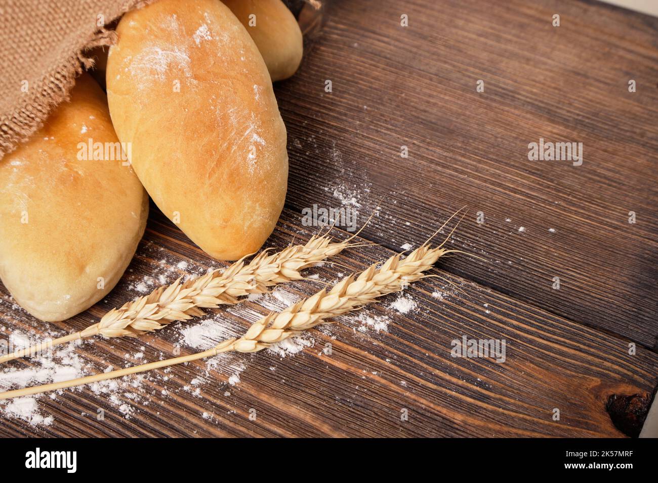 Pies, Bakery products and wheat ears on a brown wooden table Stock ...