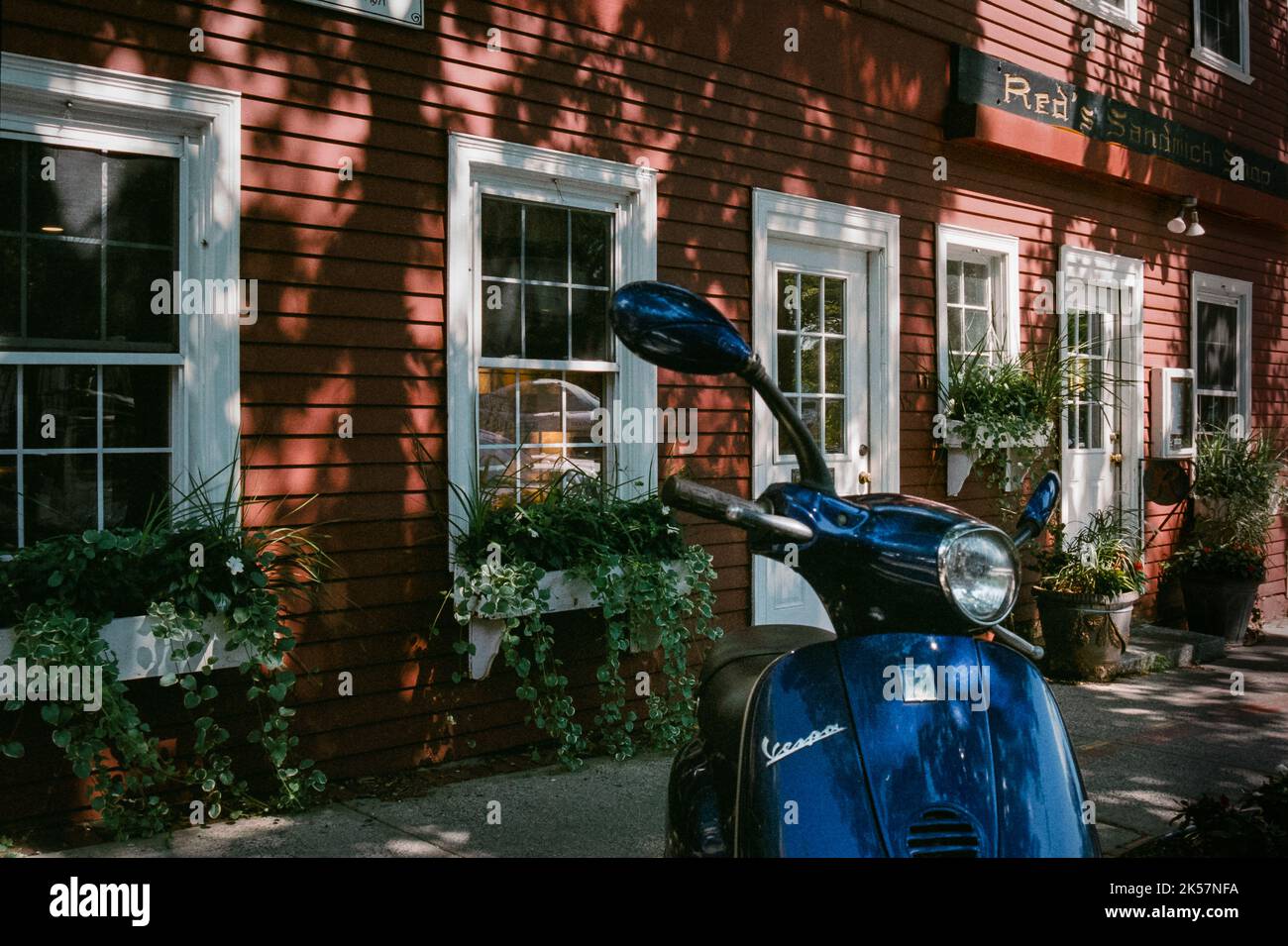A blue Vespa parked in front of a red restaurant in historic Salem ...