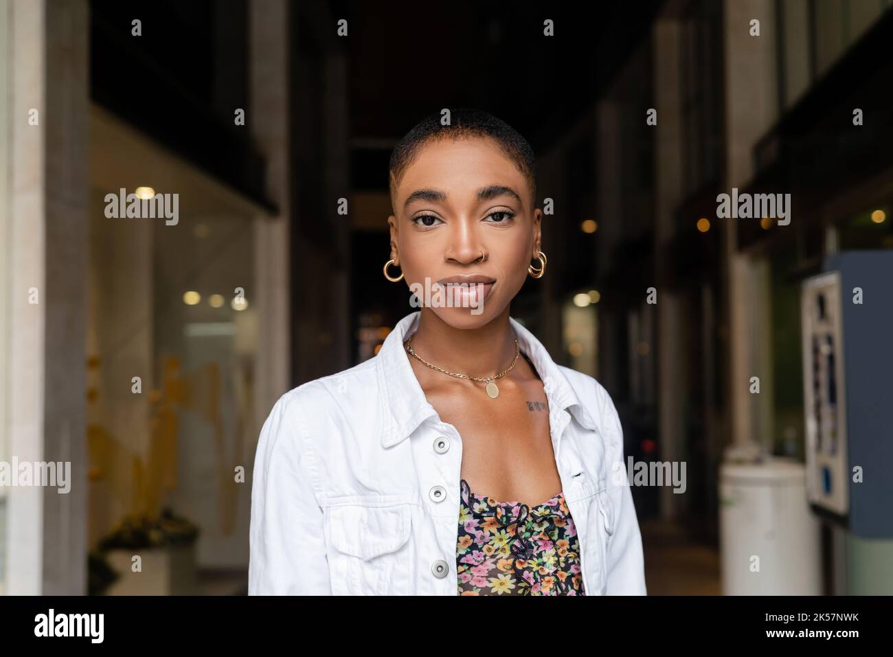 Portrait of stylish african american woman looking at camera on blurred ...