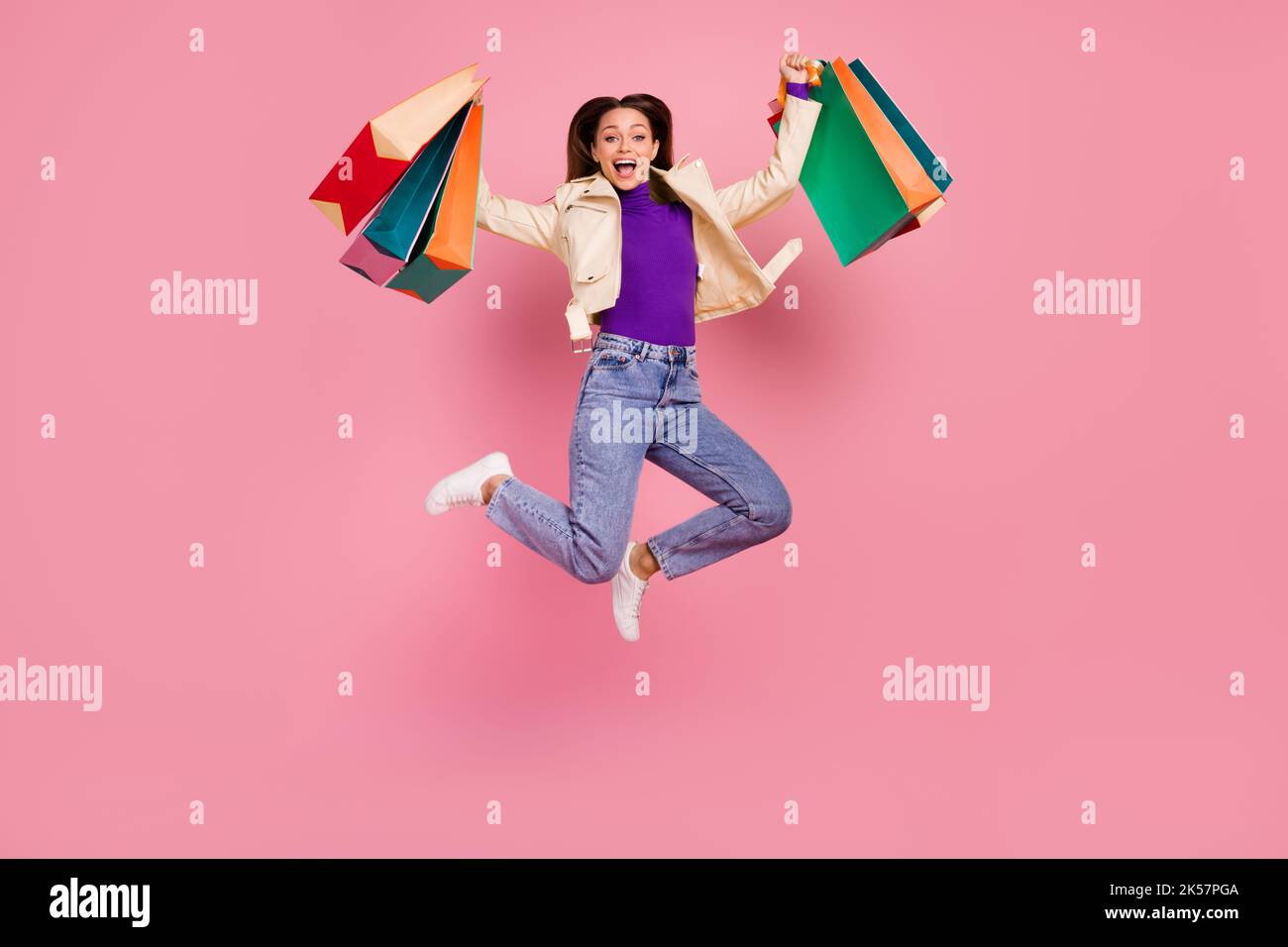 Full size photo of cool young lady jump with bags wear jacket jeans ...