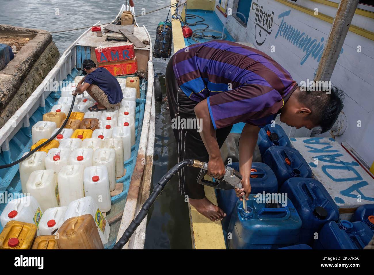 Fishermen fill up jerrycans with subsidized diesel fuel on their ...