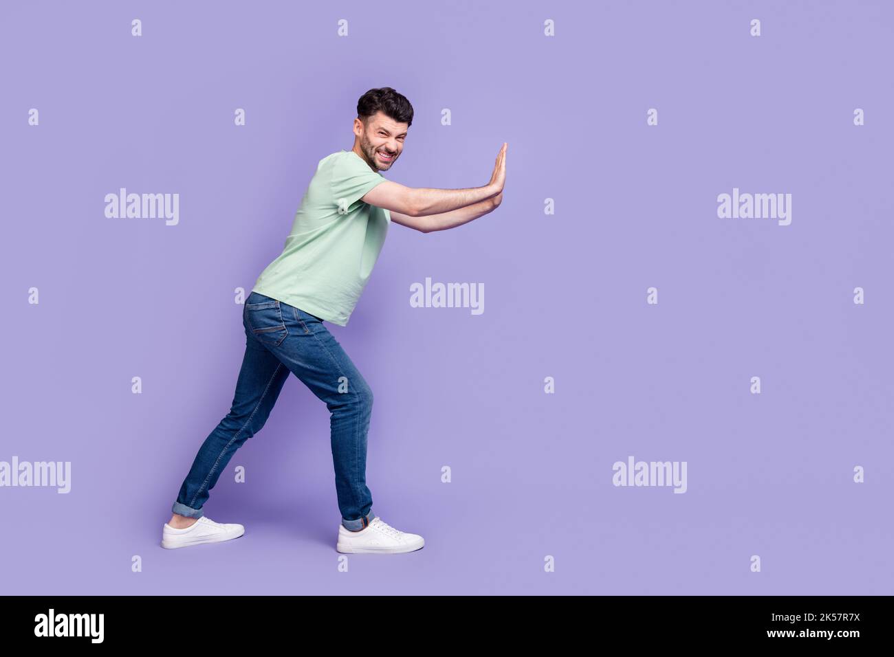 Full body photo of attractive young guy pushing hard copyspace ...