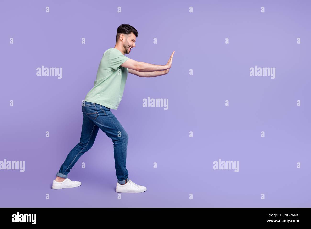 Full length photo of nice young guy pushing invisible wall empty space ...