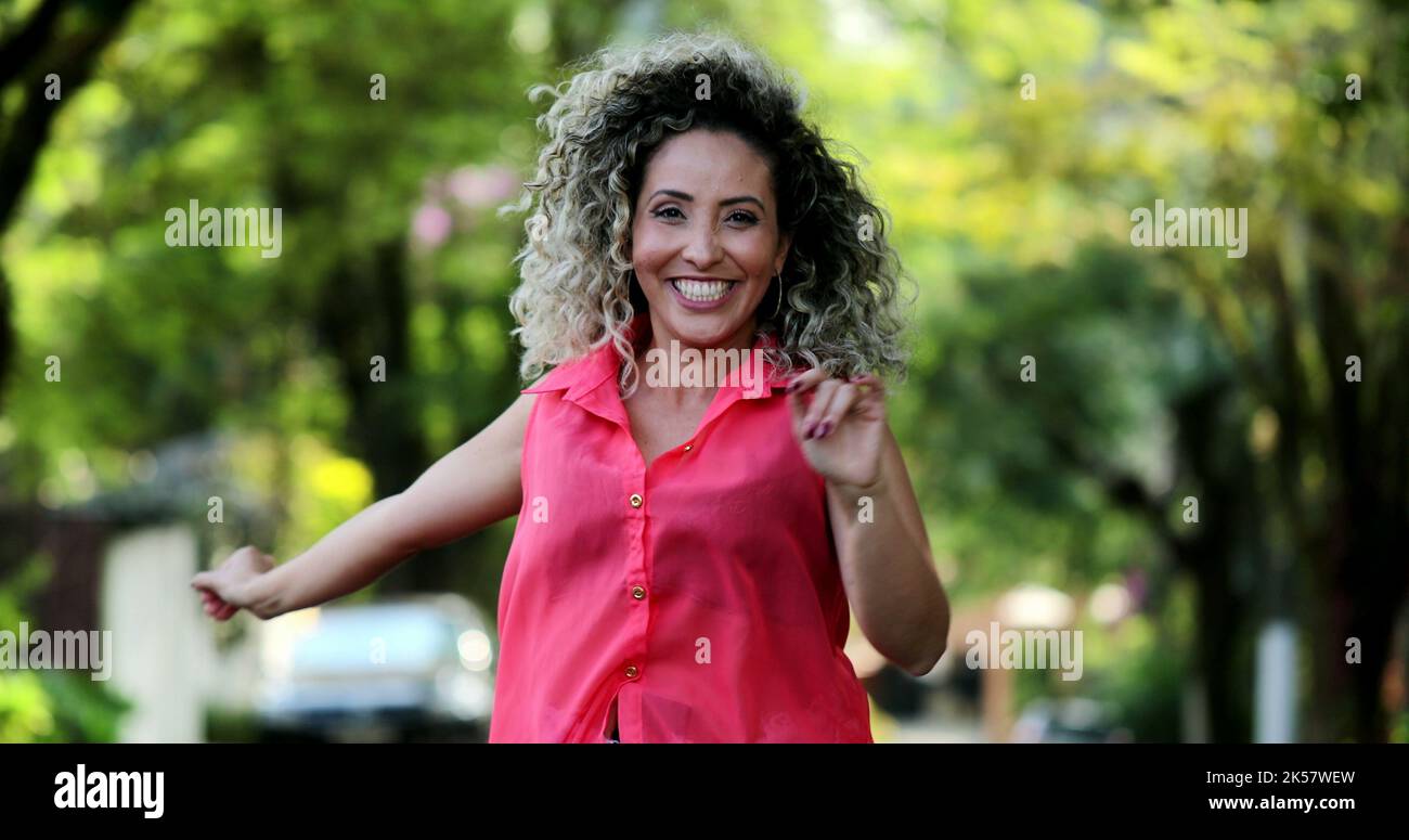 Happy hispanic woman dancing outside celebrating life Stock Photo - Alamy