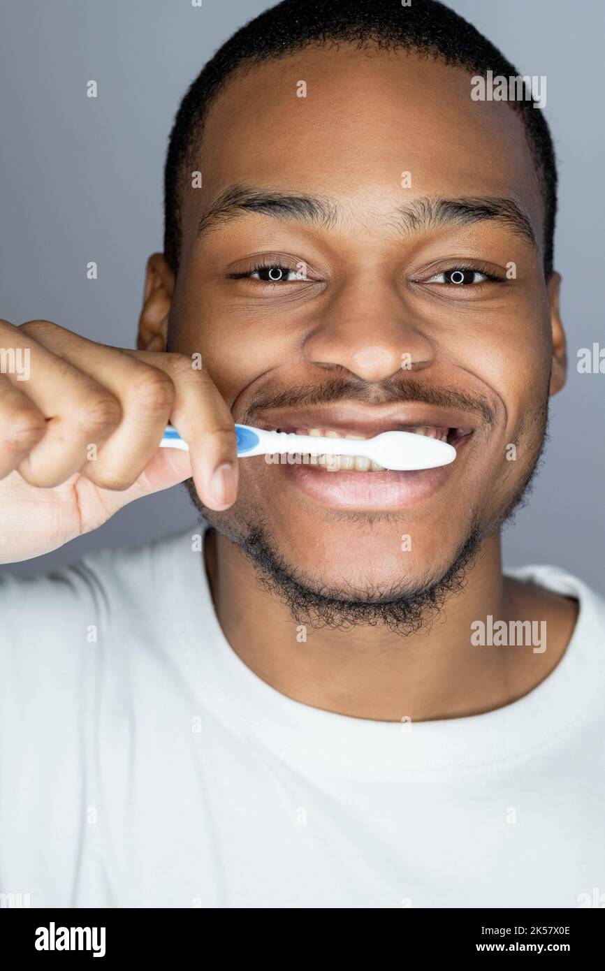 Tooth care. Dental hygiene. Oral health. Cleaning whitening. Portrait of happy handsome African ...