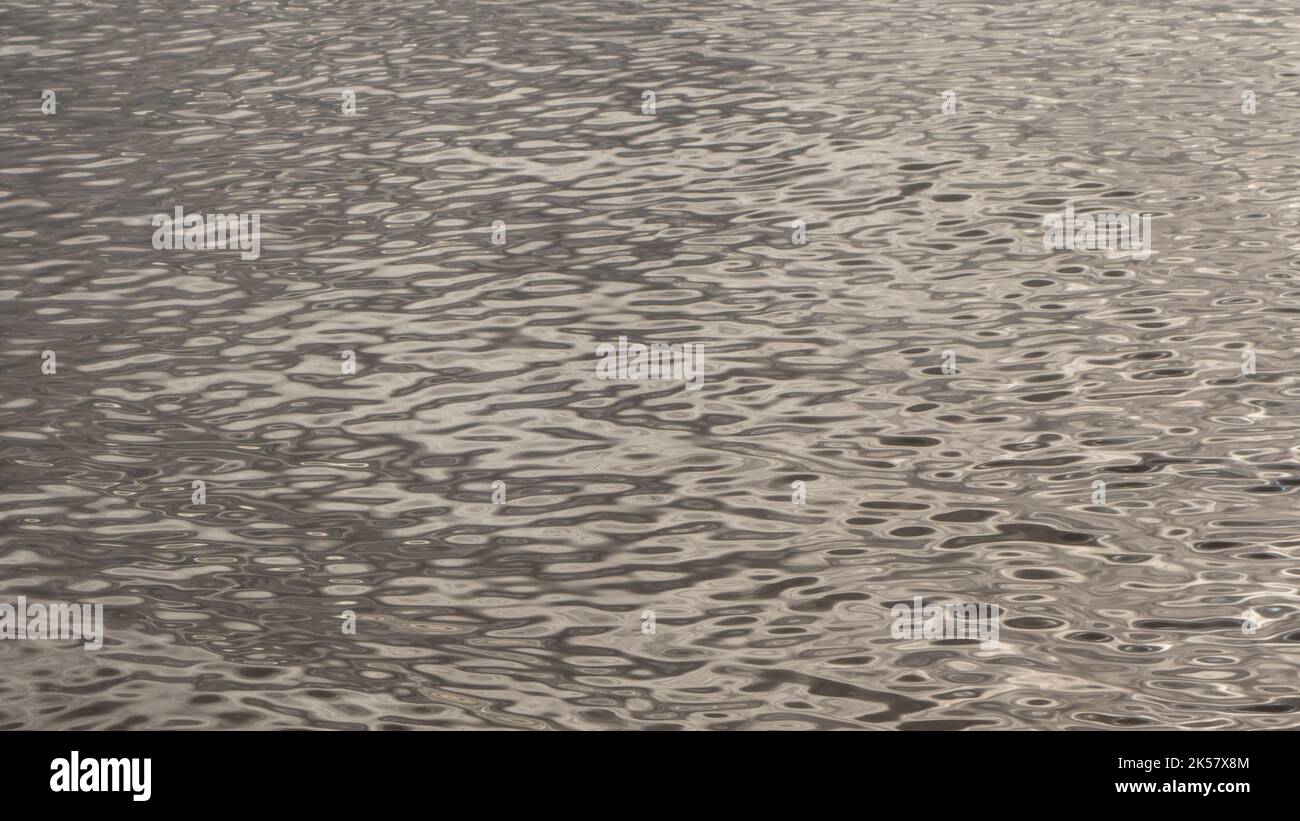 Gray water background with small ripples on the surface Stock Photo - Alamy