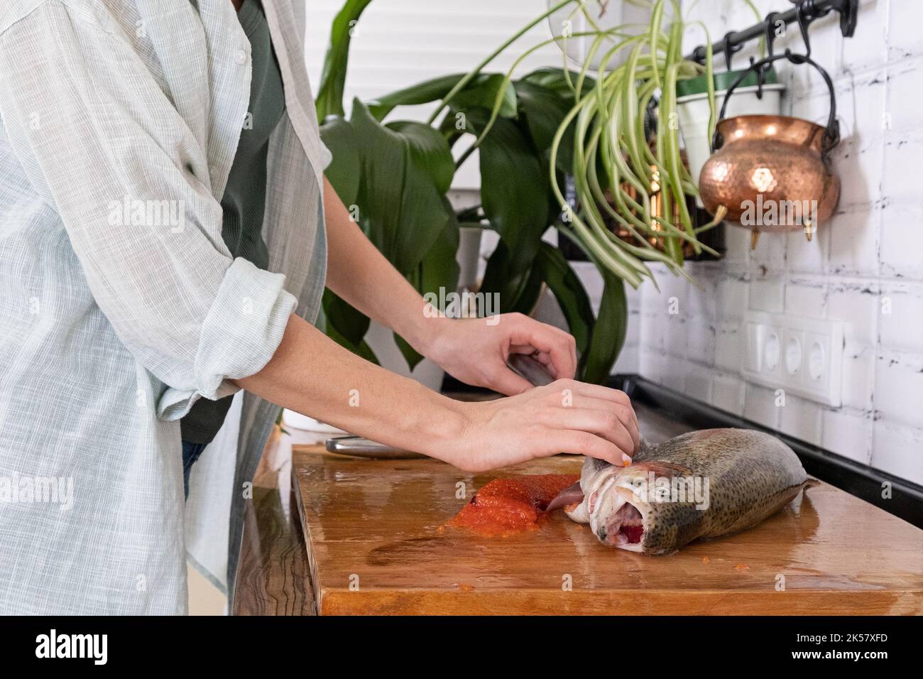 Female hands cutting fillet of red fish. Red caviar. Removing fish ...