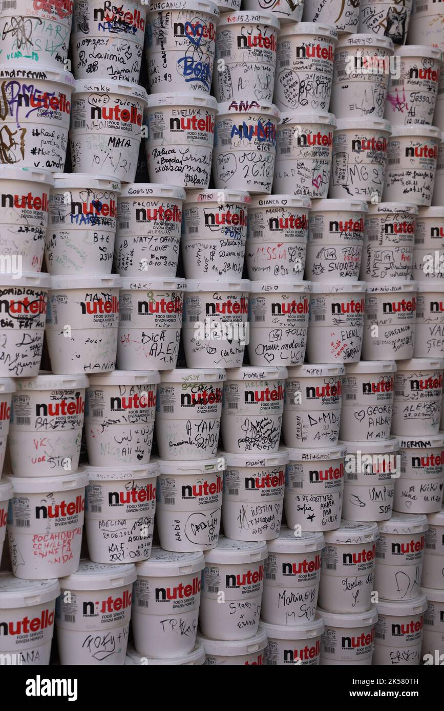 Closeup of a pile (tower) of used white Nutella containers with texts ...