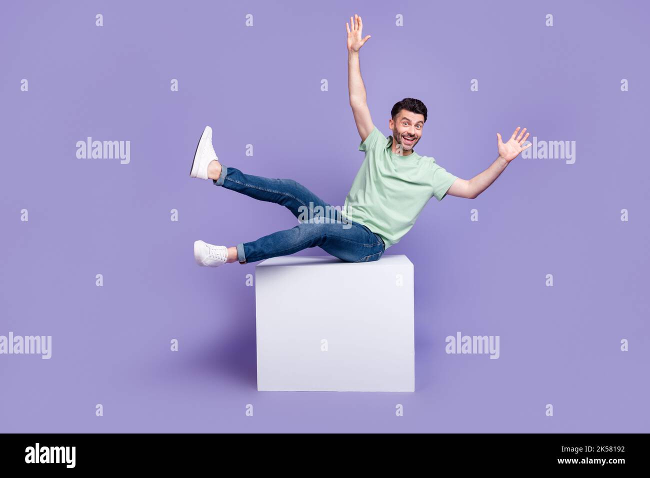 Full length photo of nice young guy sit white cube copyspace falling ...