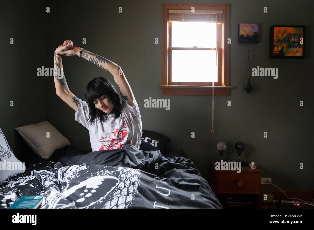 Young transgender woman with tattoos stretching in bed Stock Photo - Alamy