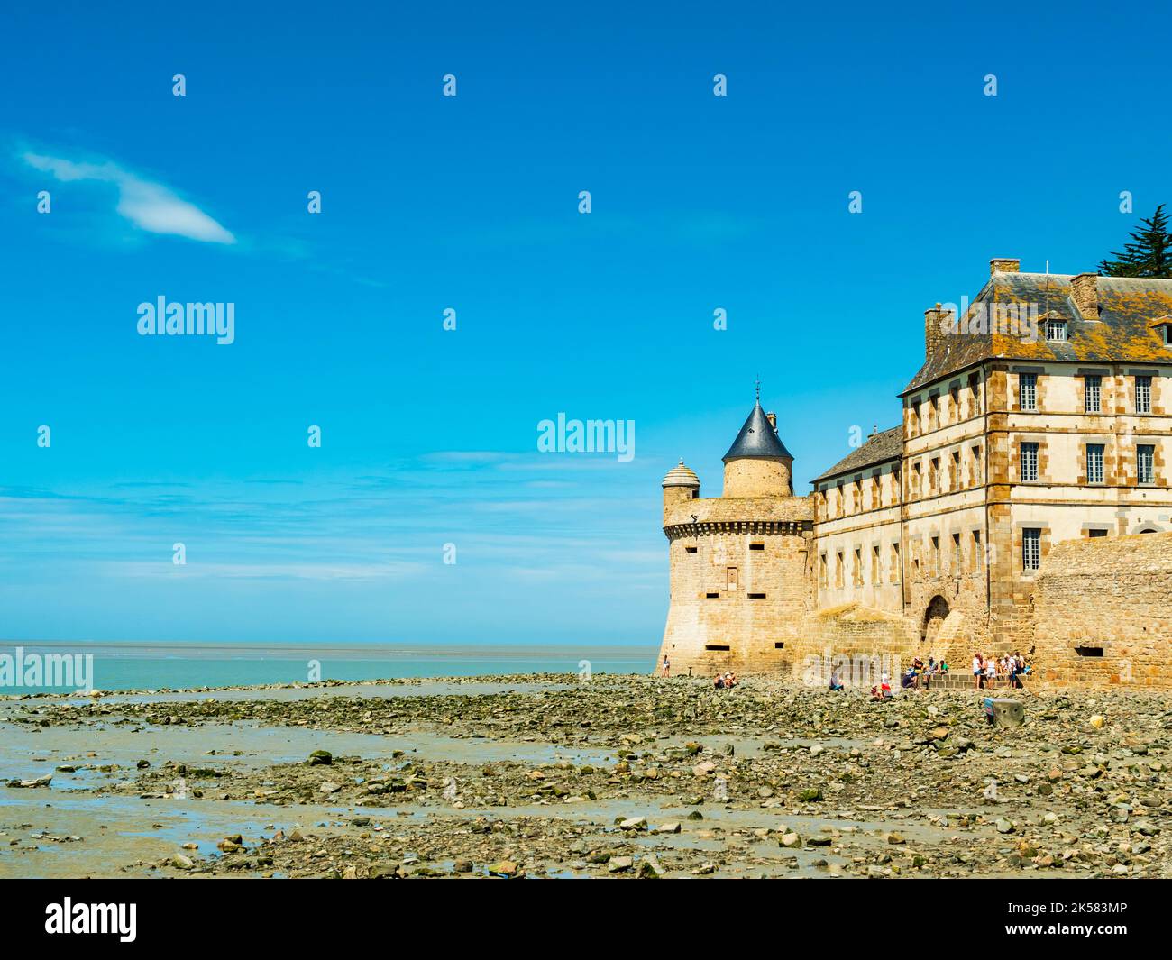 Tourists take a break in the beach surrounding Le Mont Saint Michel ...