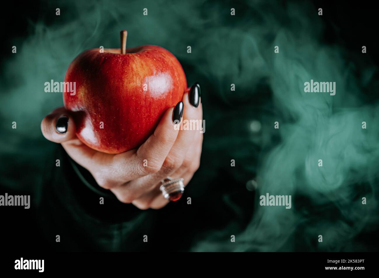 Woman as witch offers red apple as symbol of temptation, poison. Fairy ...