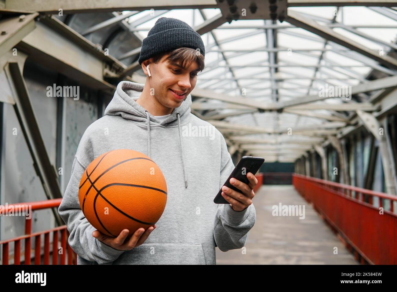 Young man basketball player with headphones holding ball using ...
