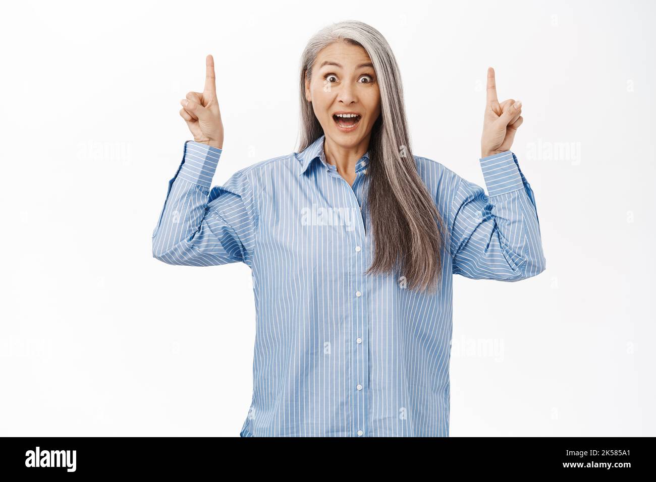 Excited asian old lady, healthy korean woman pointing fingers up ...