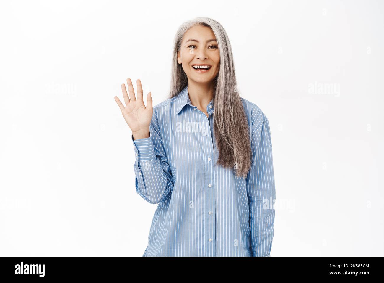 Smiling senior woman with grey hair, middle aged asian lady saying ...