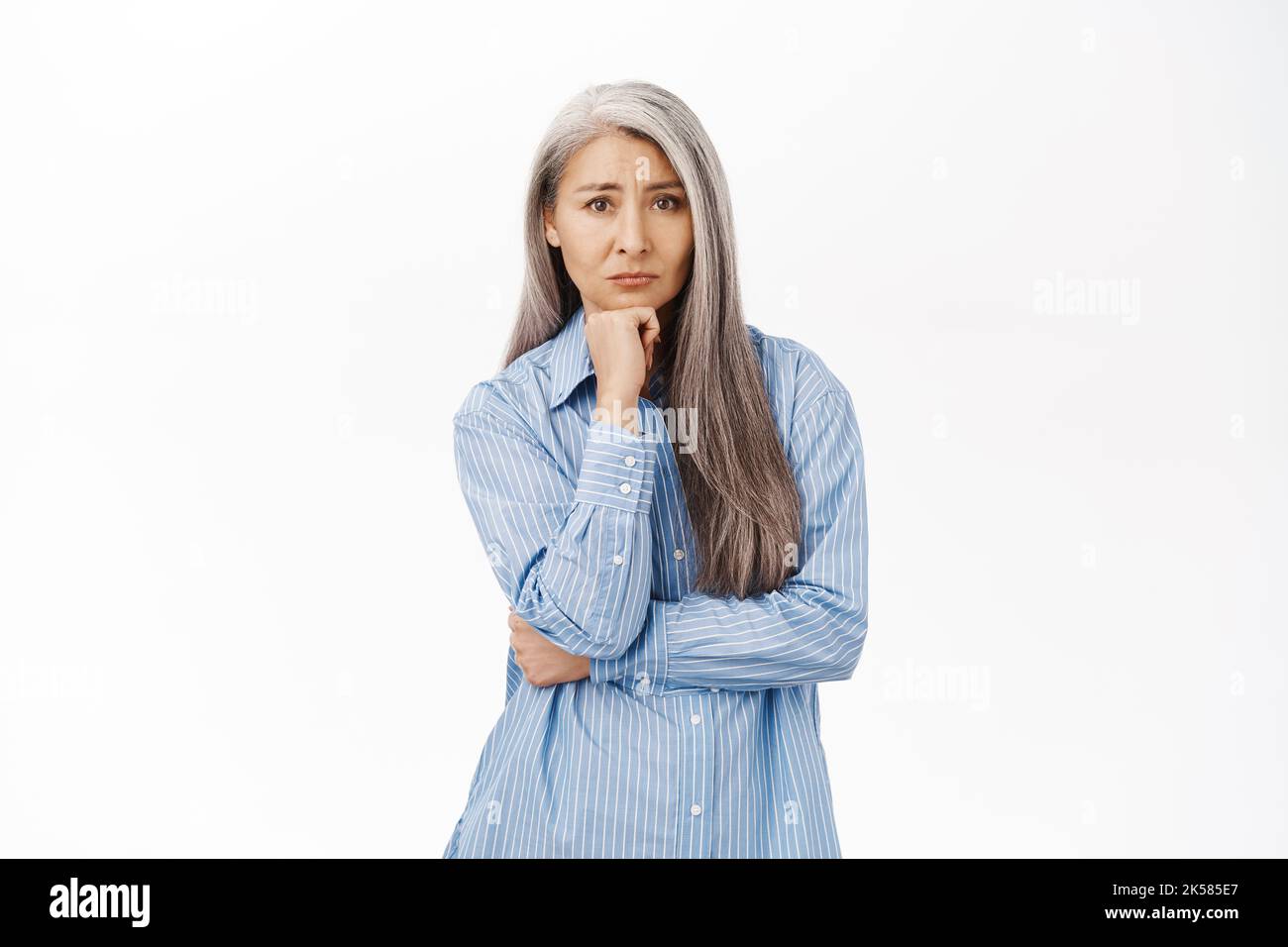 Image of worried asian lady looking with pity at camera, listening to ...