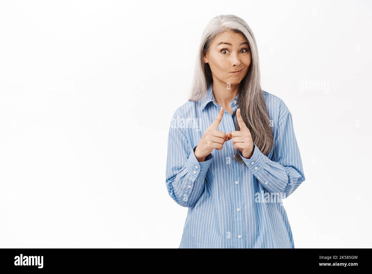 Image of cute asian woman looking innocent and shy, standing over white ...