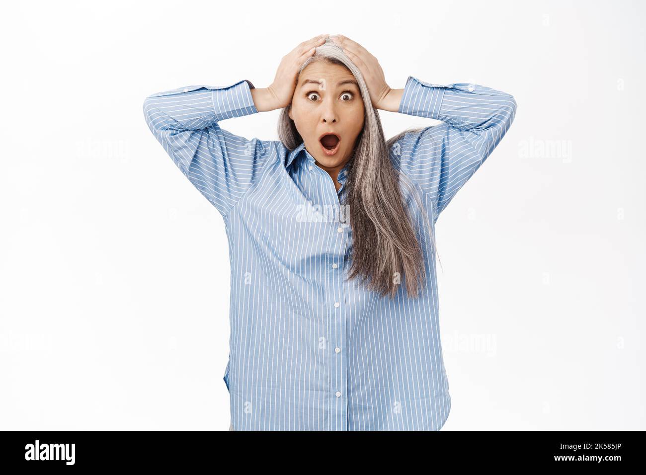 Shocked asian grandmother, senior woman looking startled and horrified ...
