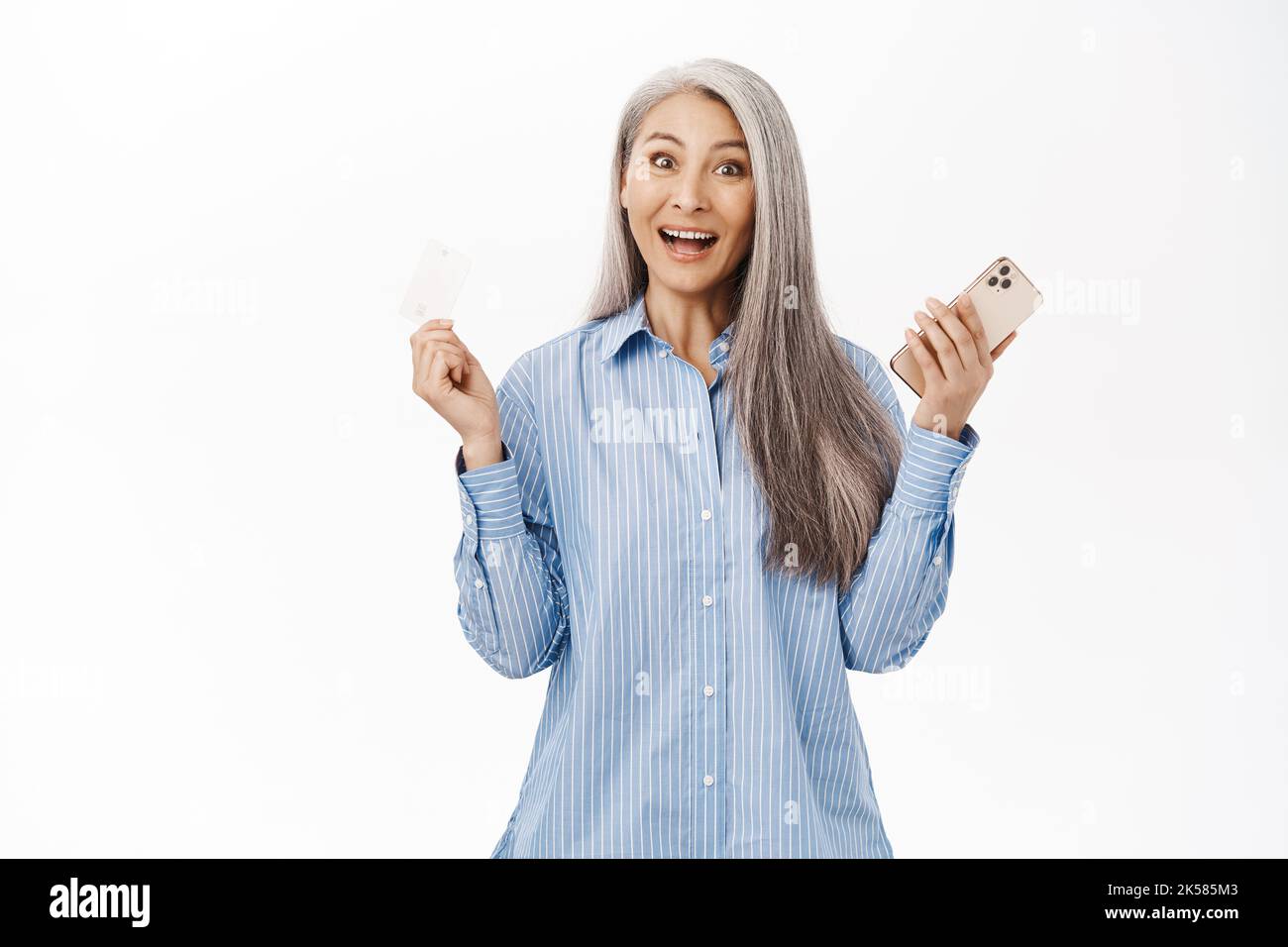 Excited asian old lady holding smartphone and rejoicing, winning online ...