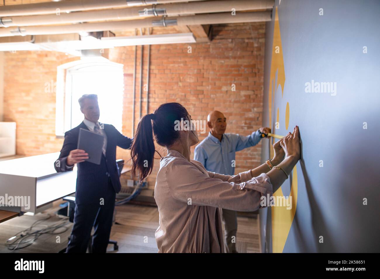 business people measuring wall in new office Stock Photo - Alamy