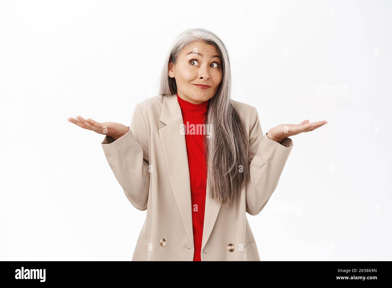 Portrait of senior asian woman shrugging shoulders, grandmother looking ...